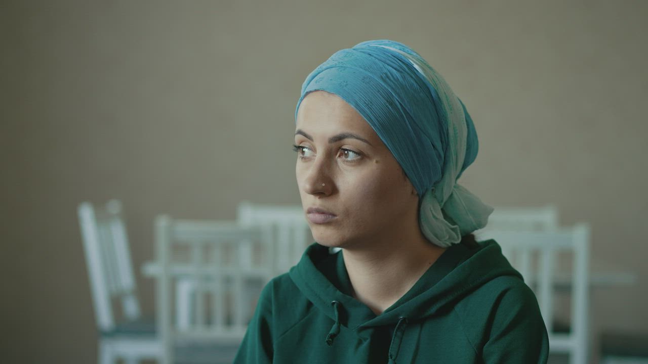 Young woman in a headscarf staring sadly ahead - Free Stock Video