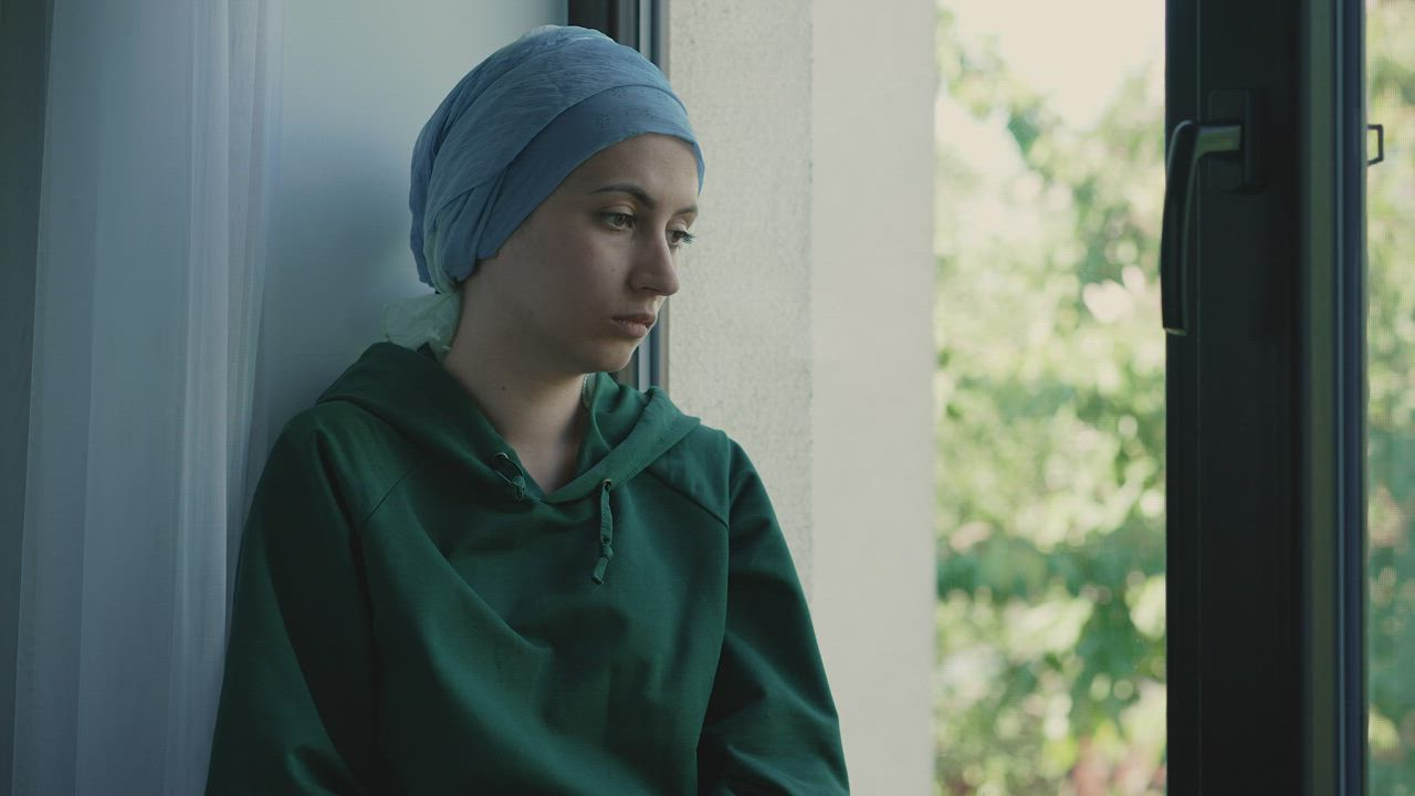 Woman looking forlorn in front of a window - Free Stock Video