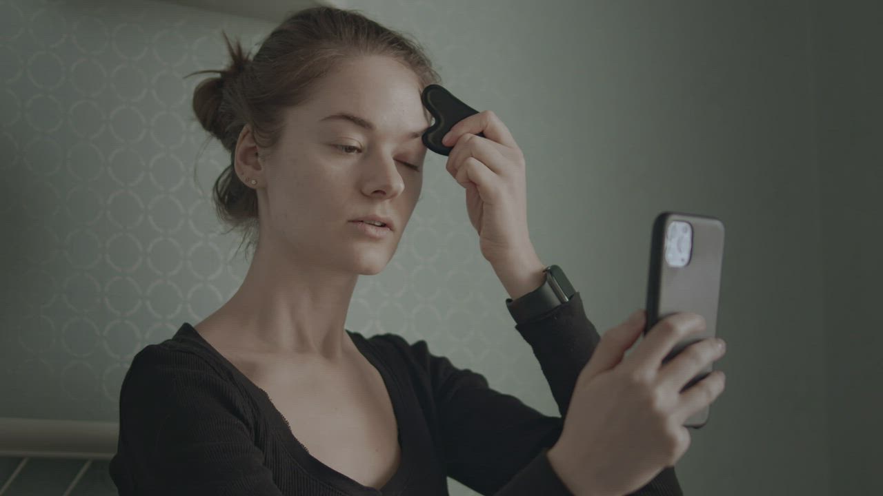 Woman using Gua Sha to sculpt her face - Free Stock Video