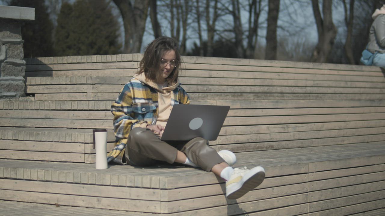 Woman working on her laptop outside in the sun - Free Stock Video