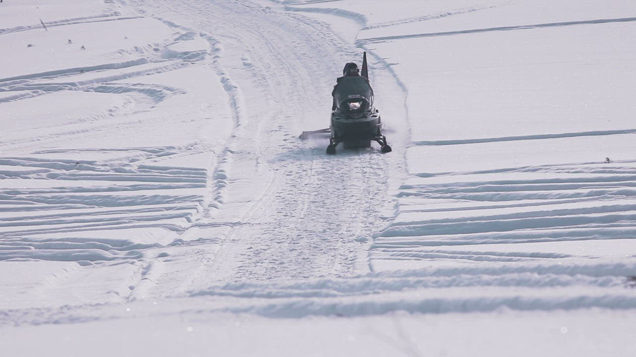 Snowmobile being driven through fresh snow - Free Stock Video