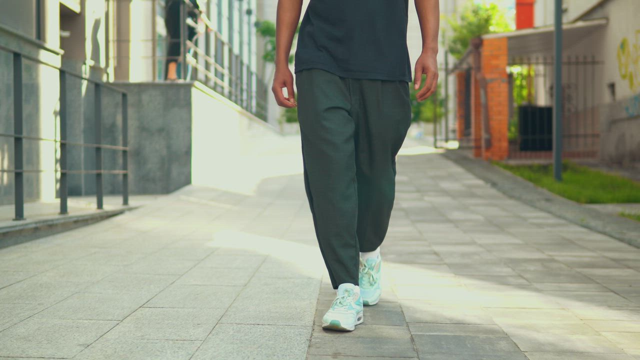 Footsteps of a young man walking down the street - Free Stock Video