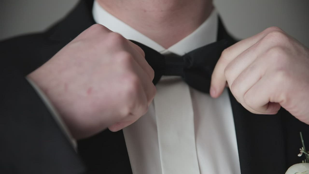 The groom Aadjusting his bow tie on his wedding day - Free Stock Video