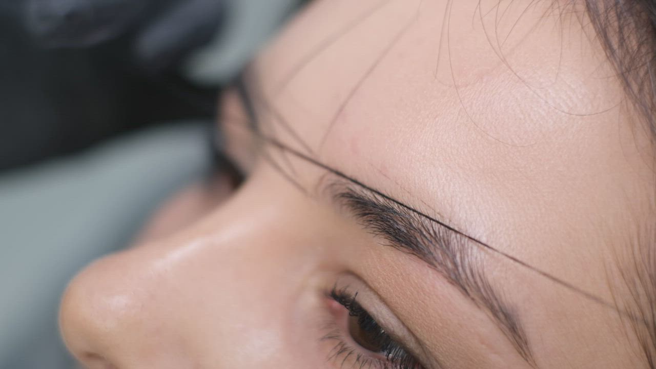 Microblading technician draws eyebrow measurements before pigmentation ...