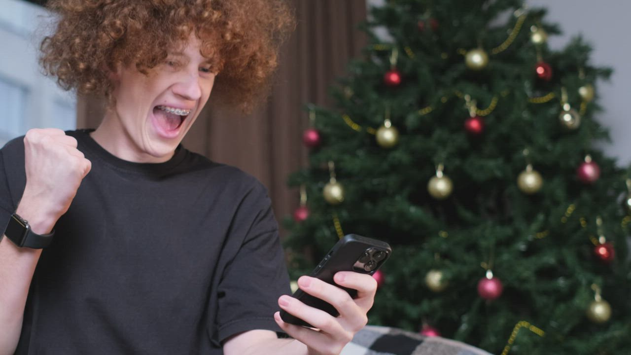 Happy young man showing happiness while checking his cell phone - Free ...
