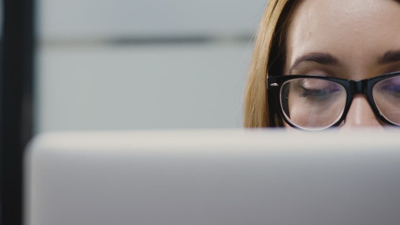Woman with glasses working on a computer - Free Stock Video