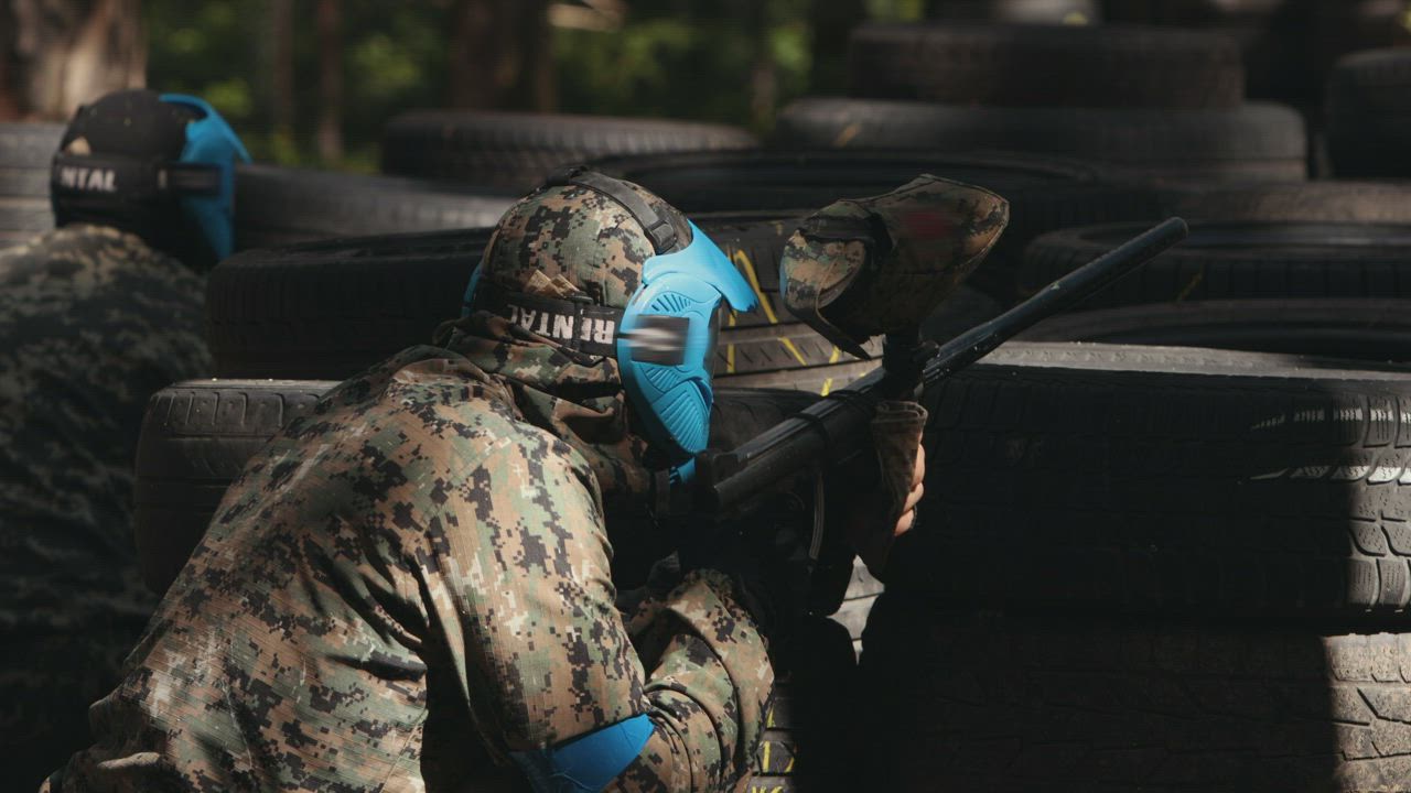 Group of adults playing paintball hidden behind barriers - Free Stock Video