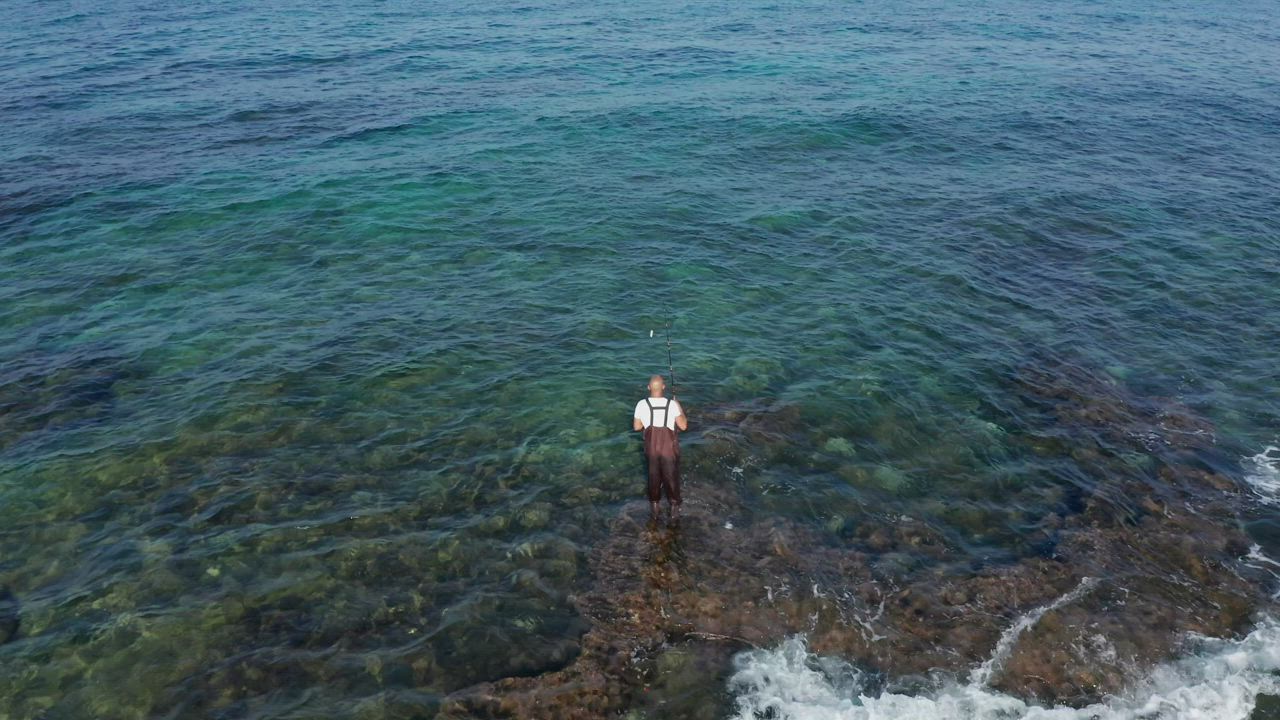 Fisherman standing in the shallows of the ocean casting a line - Free ...