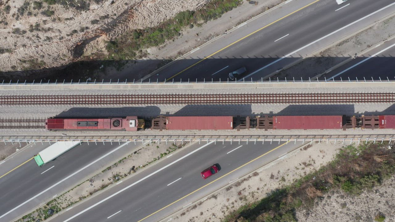 Aerial view of a freight train moving over a busy highway - Free Stock ...