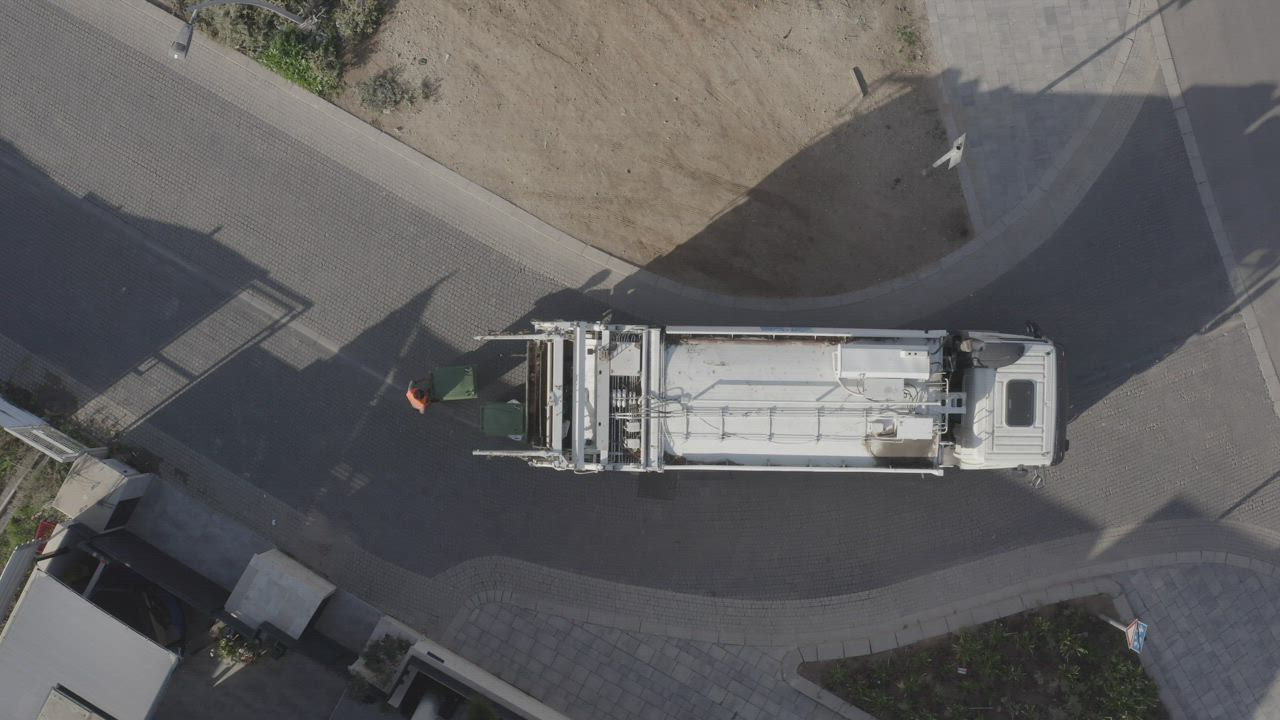 Aerial view of a garbage truck removing rubbish from a suburban street ...