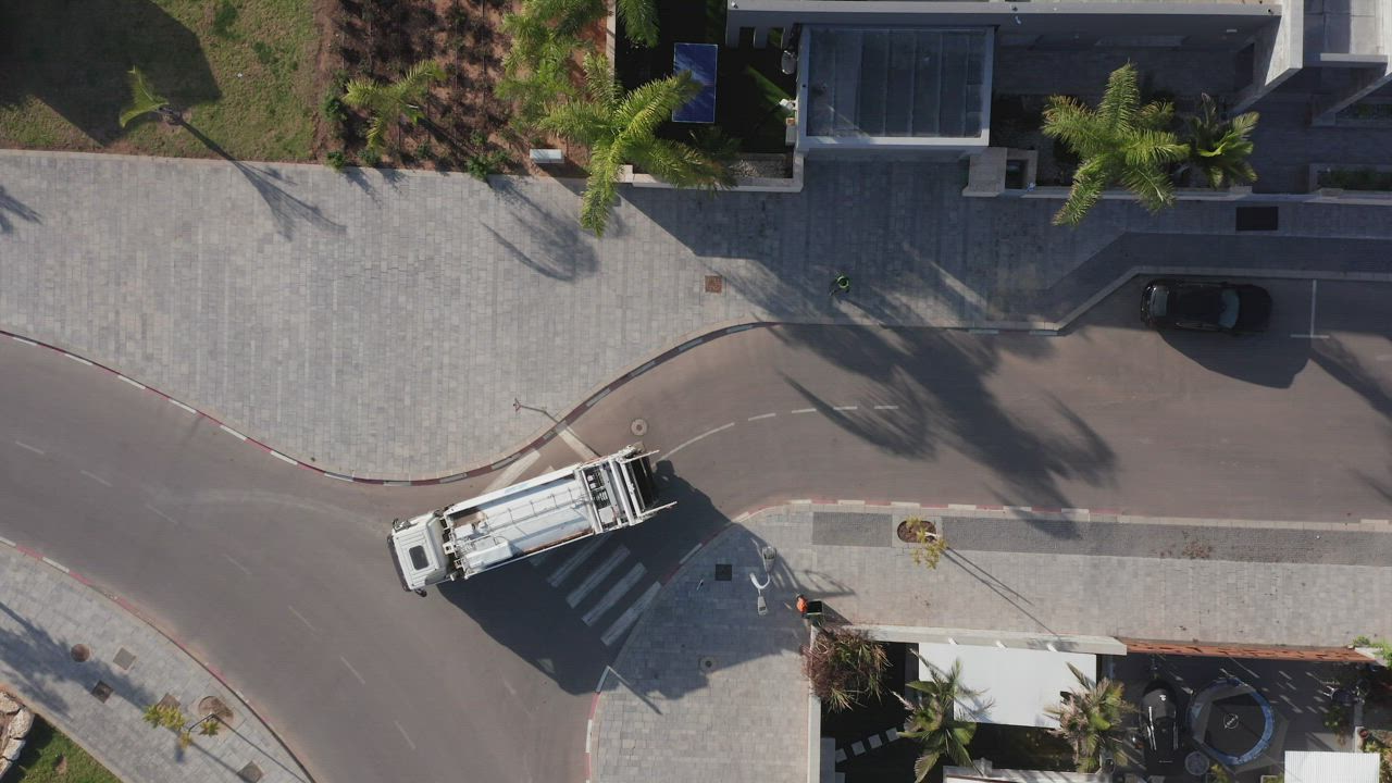 Aerial view of waste collectors removing rubbish in the early morning ...