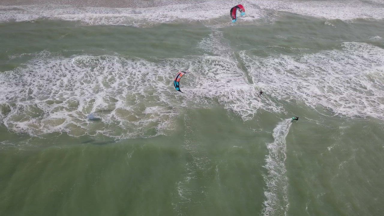 Kitesurfer riding waves across the ocean waves - Free Stock Video
