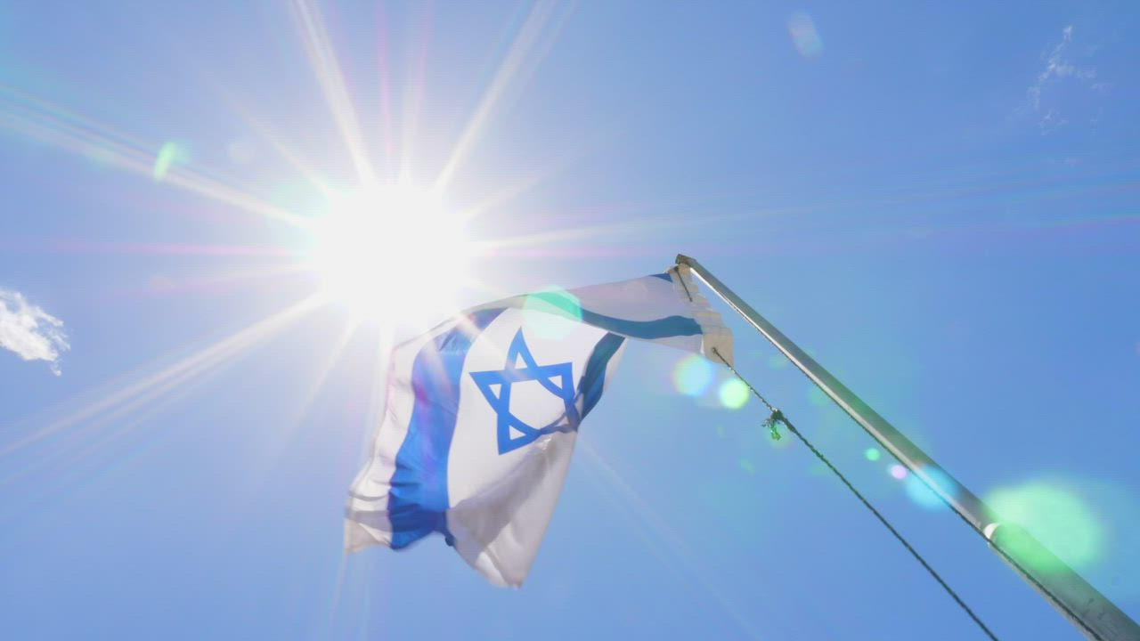 Israeli flag waving in the wind high on a flagpole - Free Stock Video
