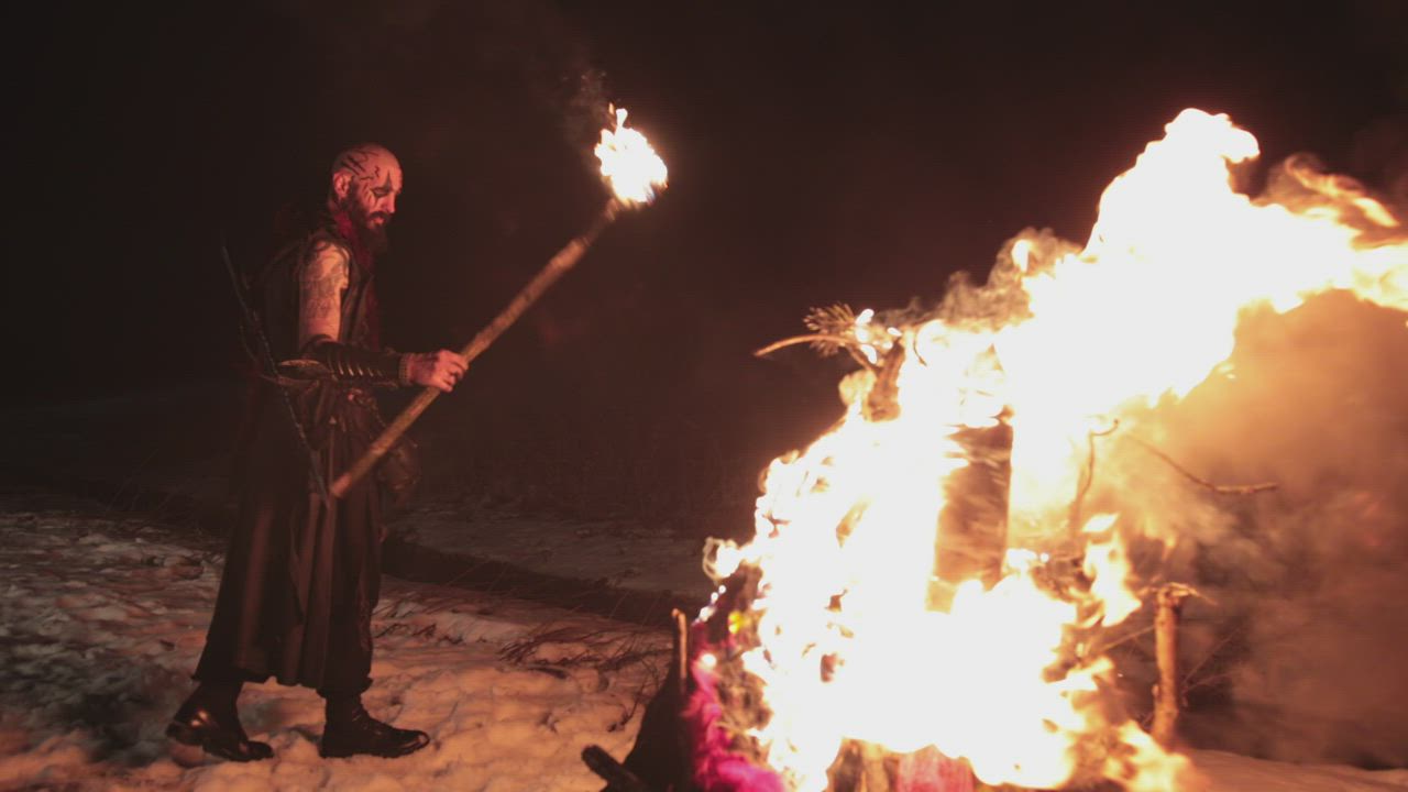 Viking with torch walking near campfire - Free Stock Video