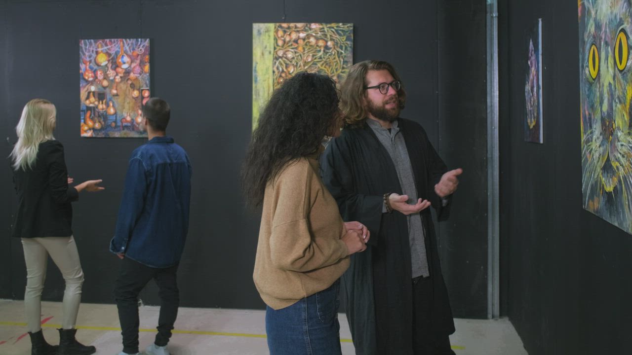 Young artist explains painting to friend at the art gallery - Free ...