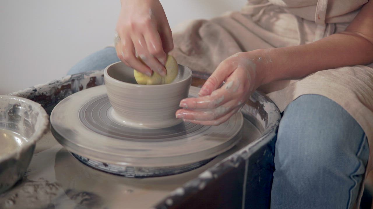 Woman works in ceramics studio making a vase - Free Stock Video