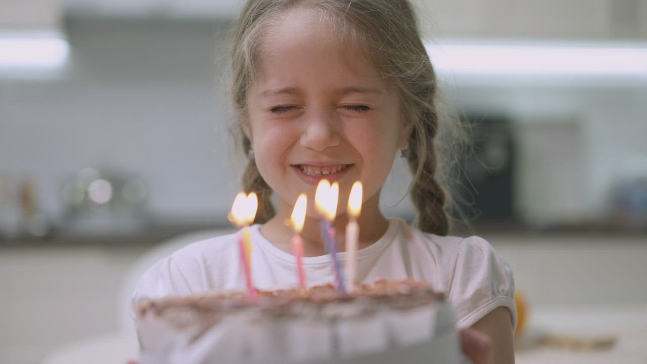 Young girl making a wish as she blows out the candles - Free Stock Video