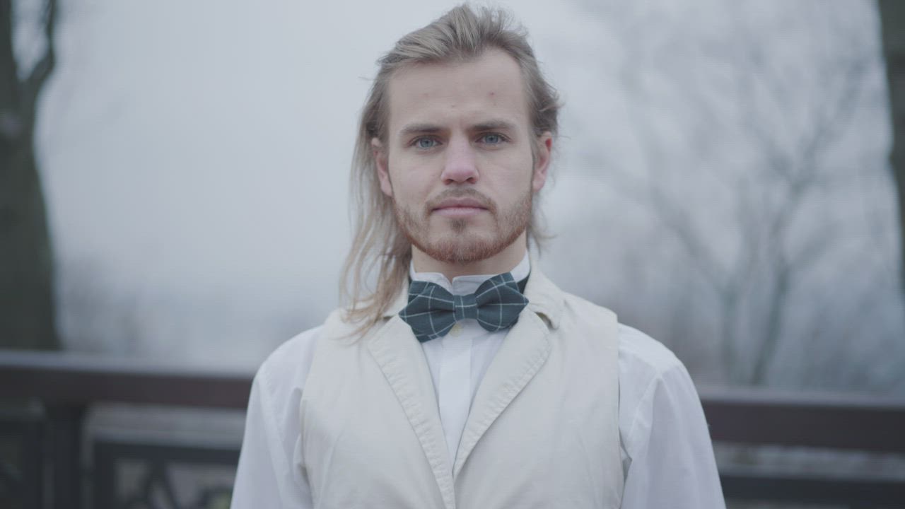 Man wearing a bowtie staring forwards at the camera - Free Stock Video