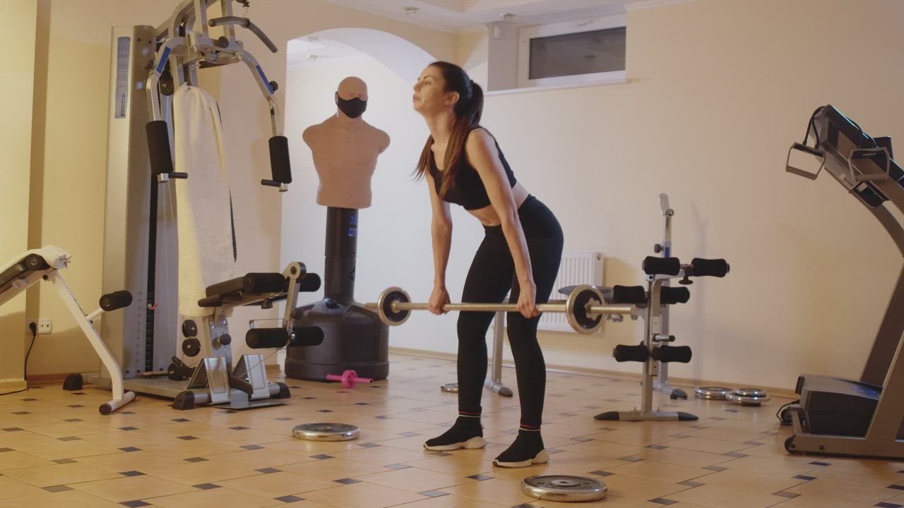 Woman practicing a deadlift in a home gym - Free Stock Video