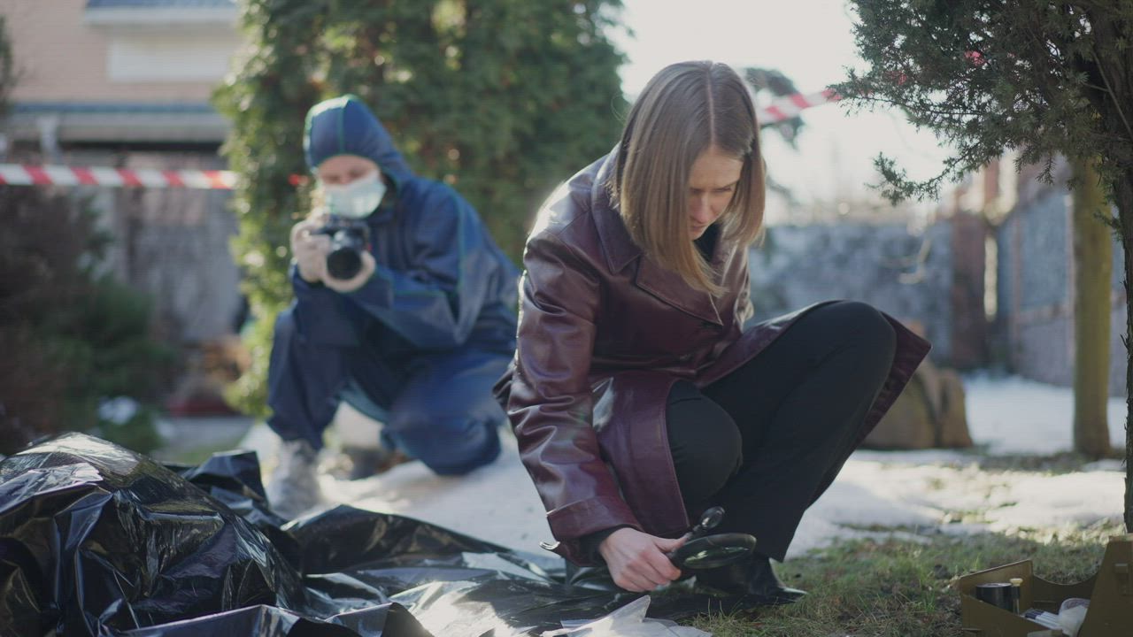 Detective examining a body at a crime scene - Free Stock Video