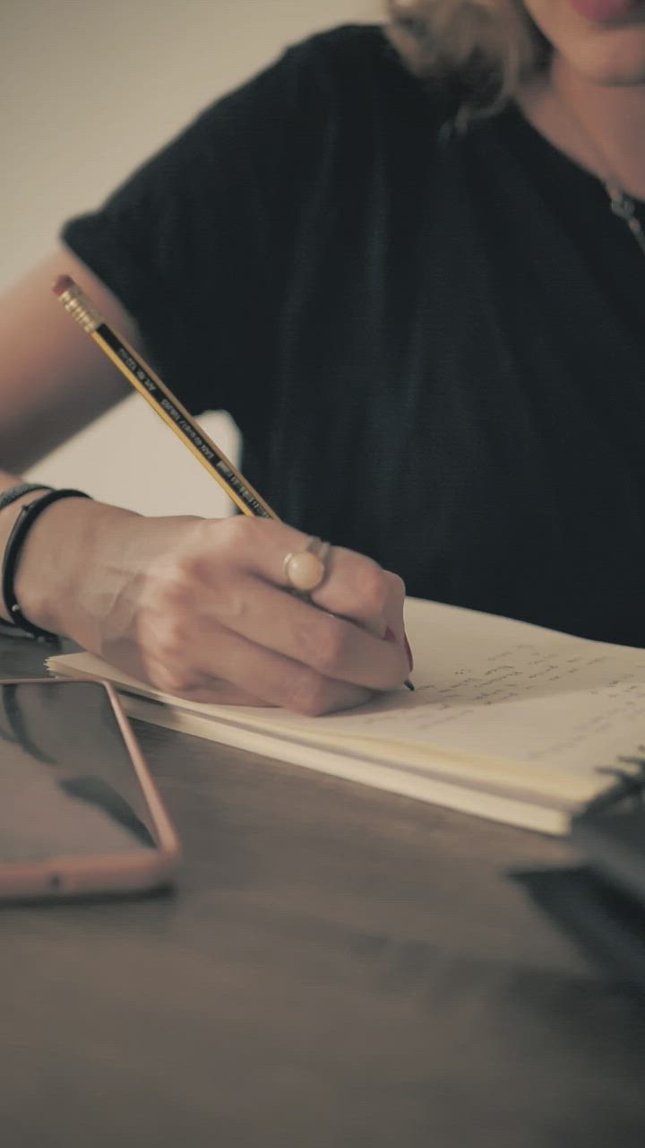 Girl in glasses writing with pencil on a notepad - Free Stock Video