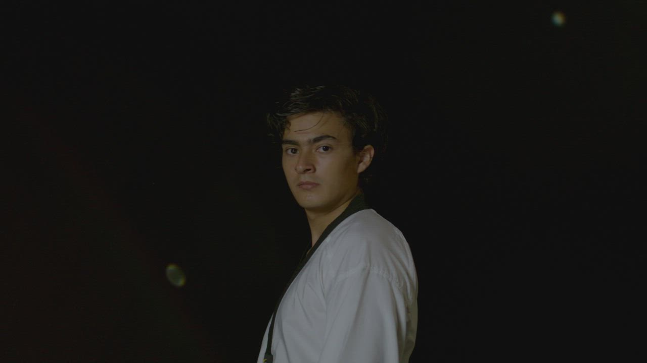 A young black belt karateka throws a punch at the camera - Free Stock Video