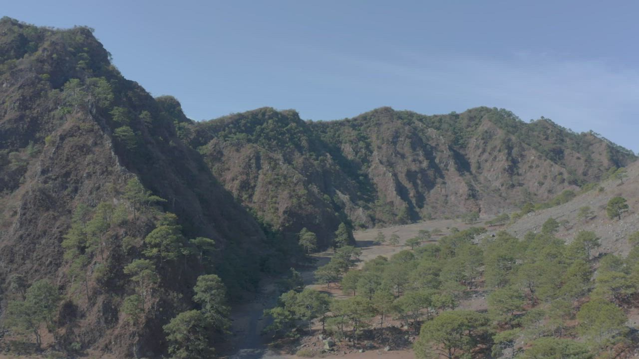 Slow aerial tour through an arid ecosystem between hills - Free Stock Video