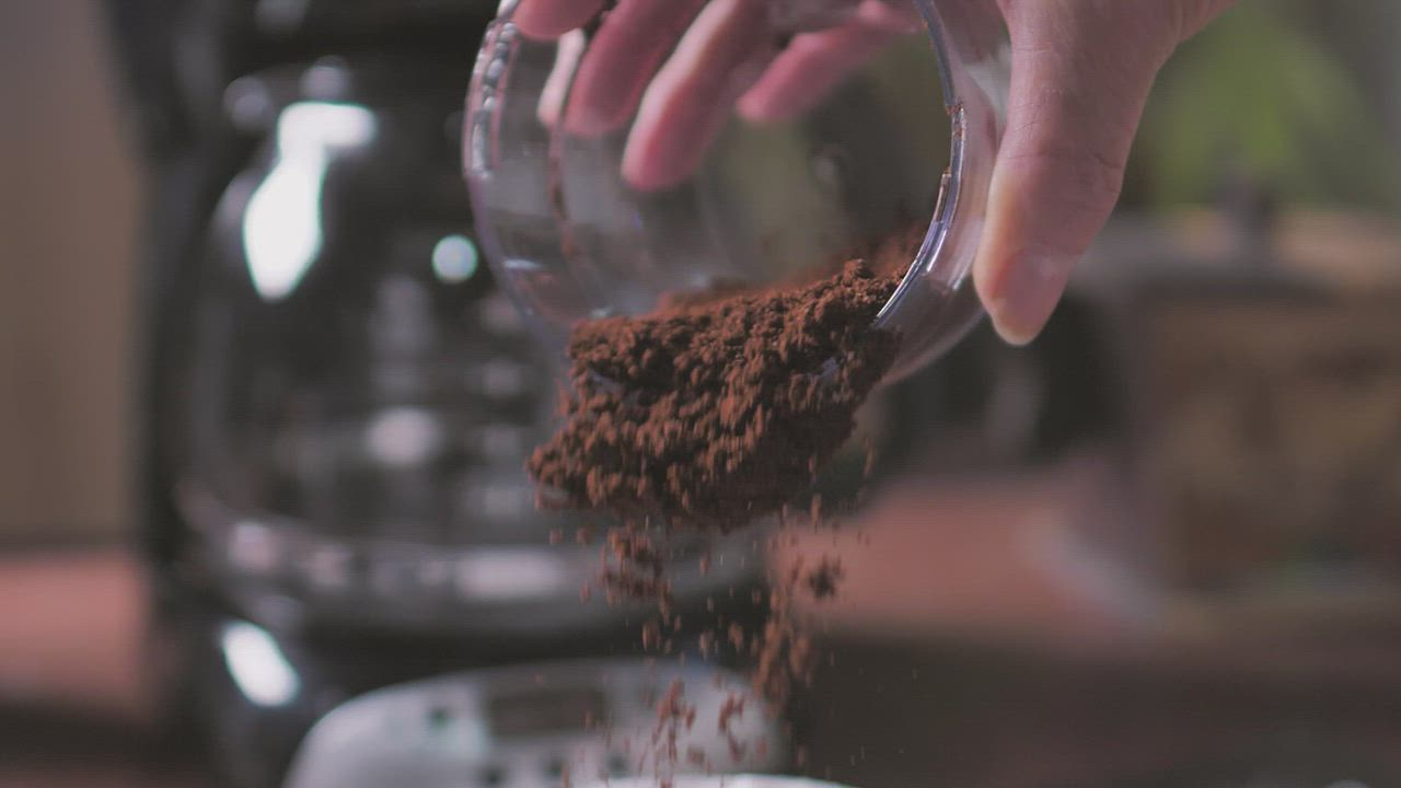 Coffee powder being poured on the coffee maker filter - Free Stock Video