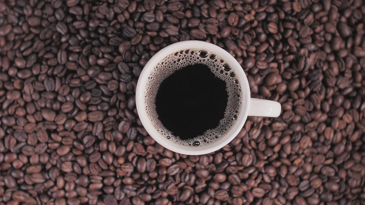 Cup of coffee on top of coffee beans - Free Stock Video