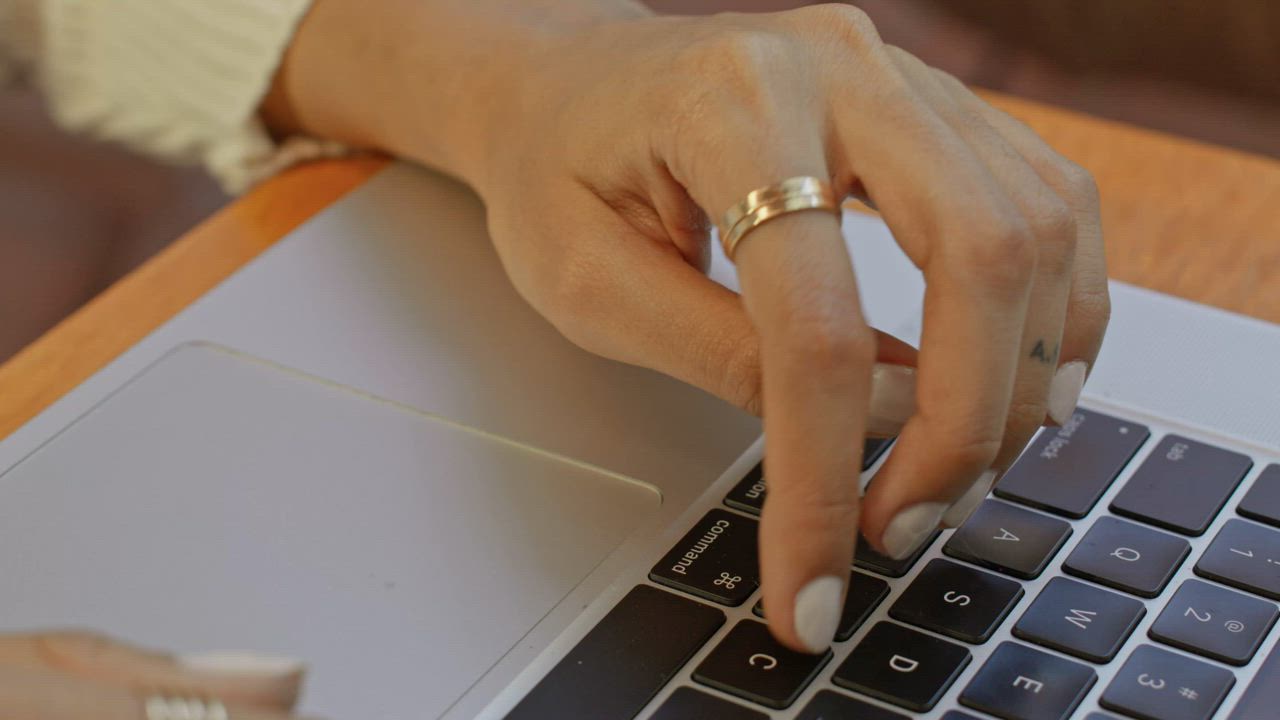 Close up shot of the hands of a woman typing on a laptop keyboard ...