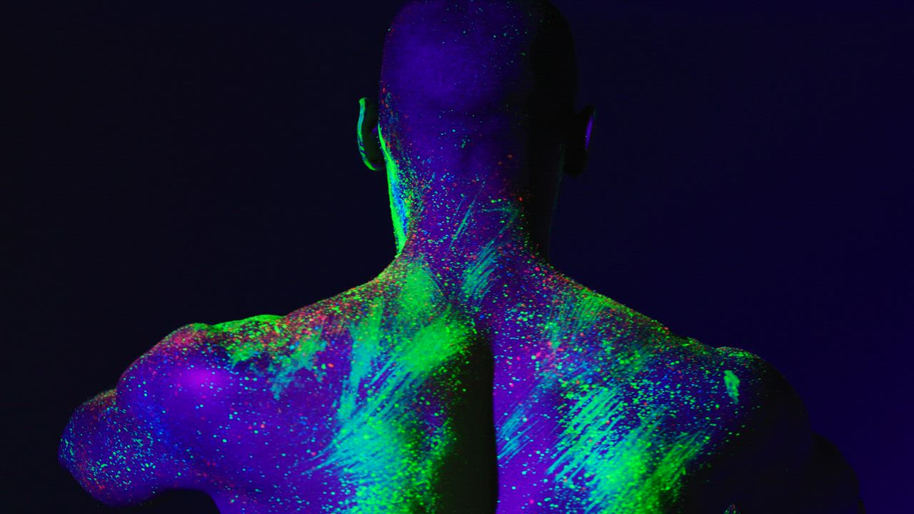 Back of a man stained with fluorescent colors - Free Stock Video