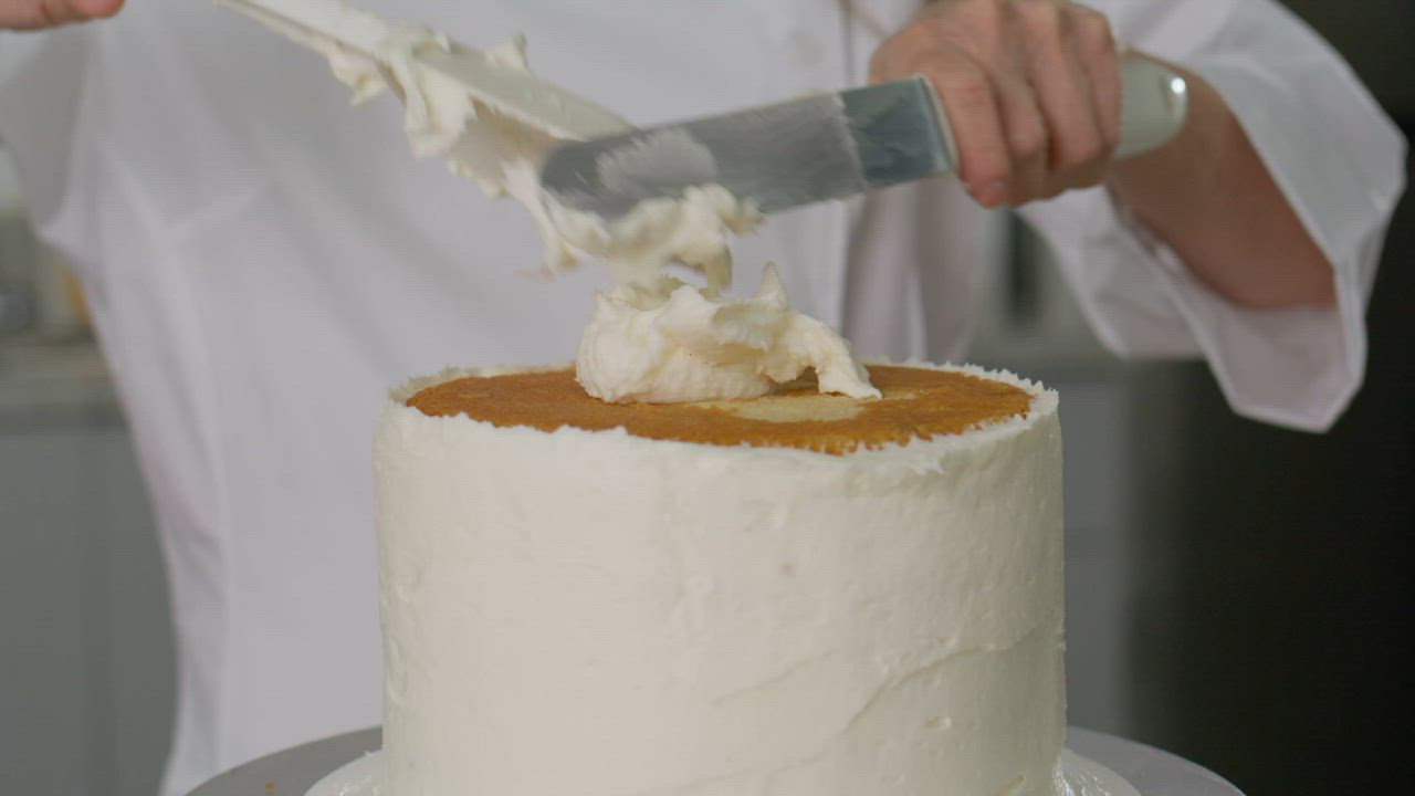 Pastry chef covering a cake with white icing - Free Stock Video