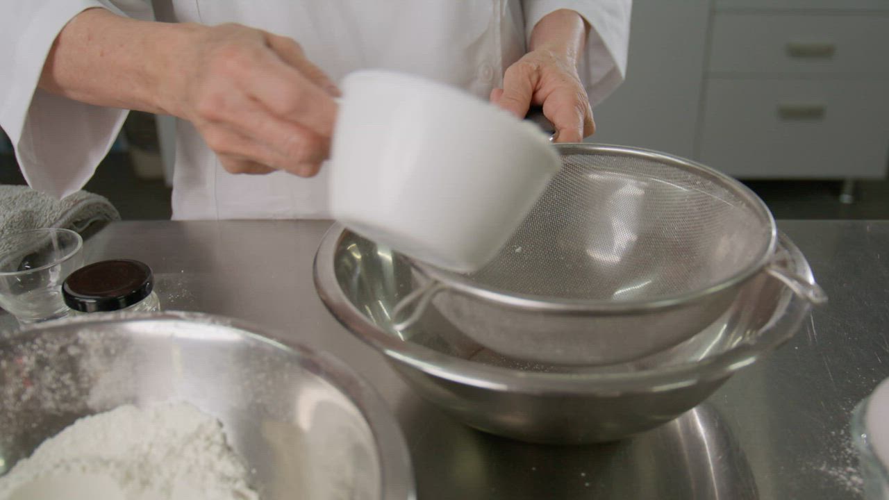 Professional pastry chef adding flour for a cake - Free Stock Video