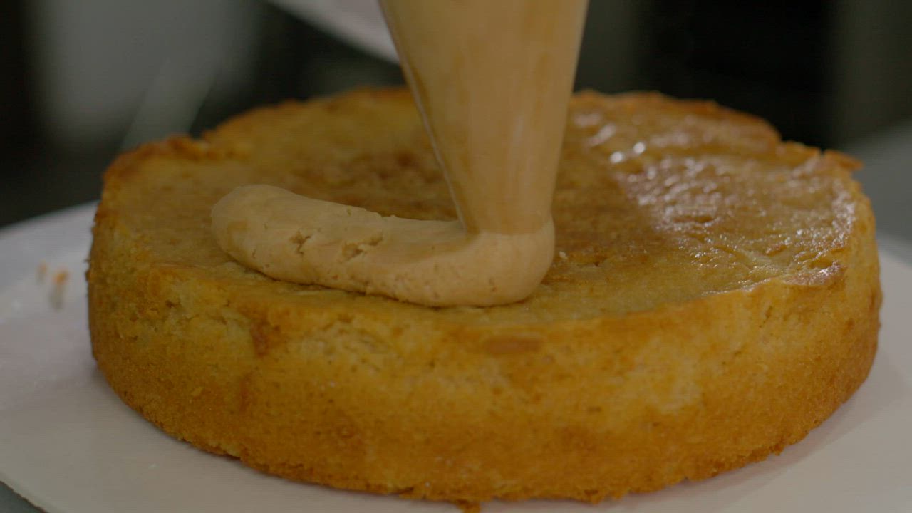 Pastry chef adding filling in the preparation of a cake - Free Stock Video