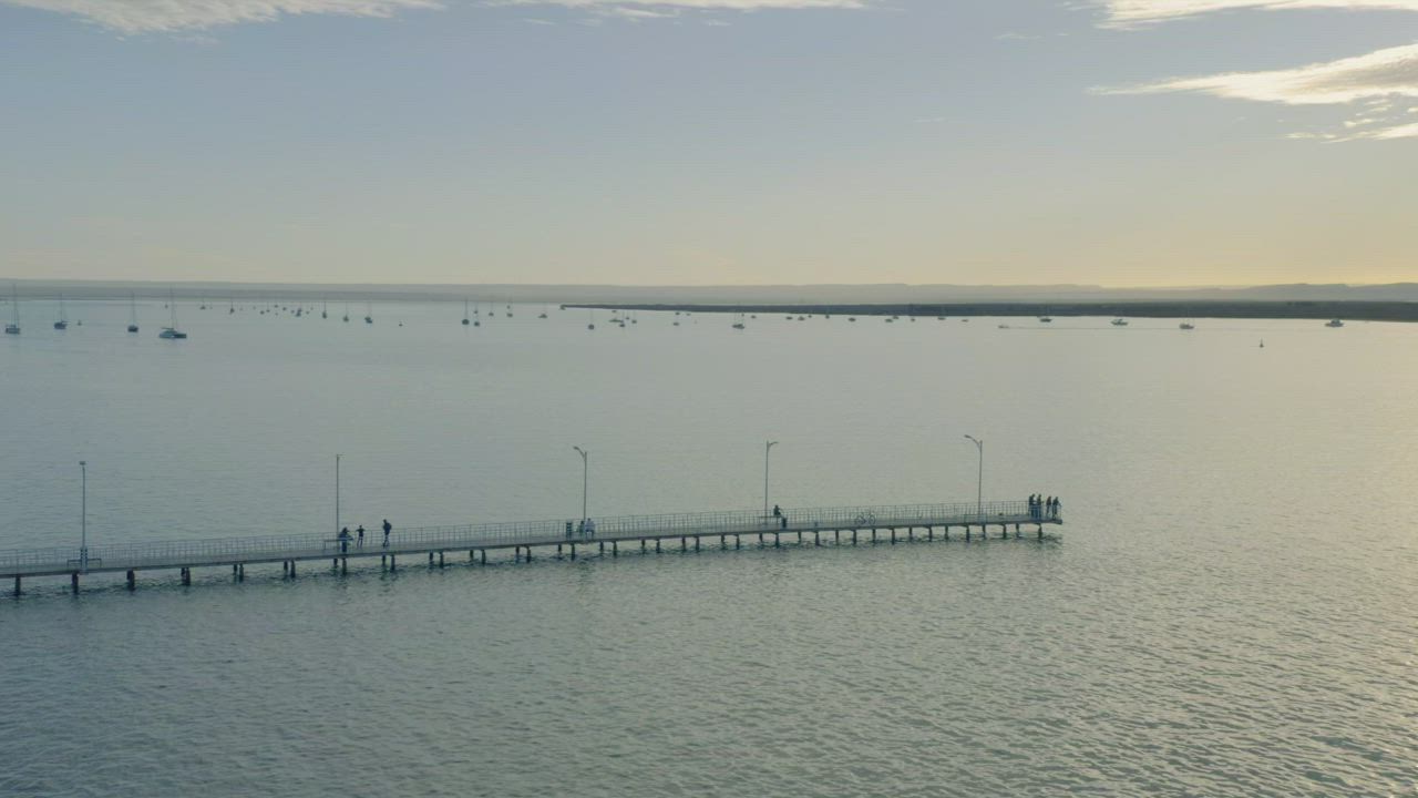Long pier in an aerial shot at sunset. - Free Stock Video