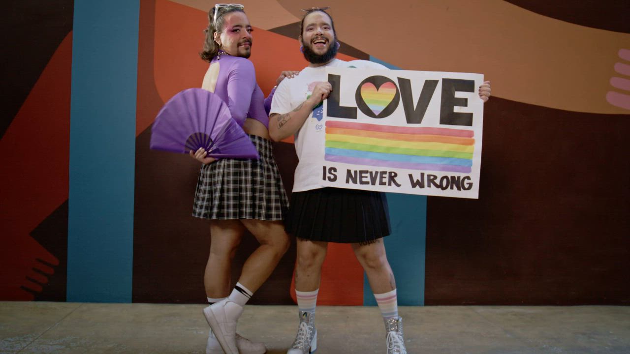 People posing side-by-side as they hold an inclusive Pride poster ...