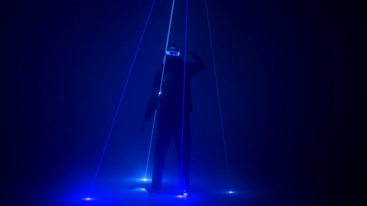 Dancer in electronic mask stands under laser lights - Free Stock Video