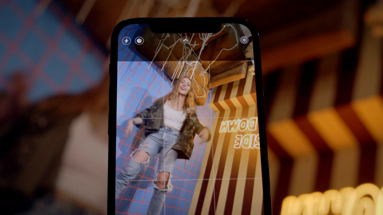 A young cheerful woman being recorded posing and modeling in upside ...