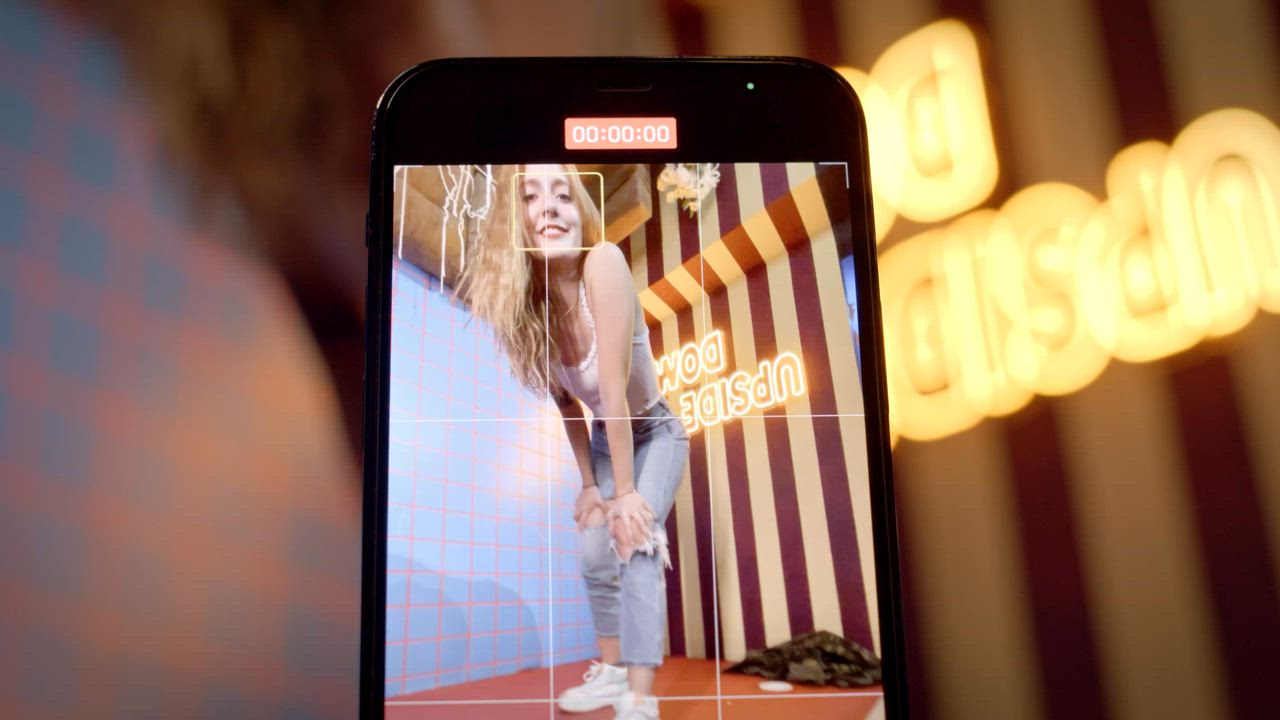 Smarphone recording a young woman posing and modeling in upside down ...