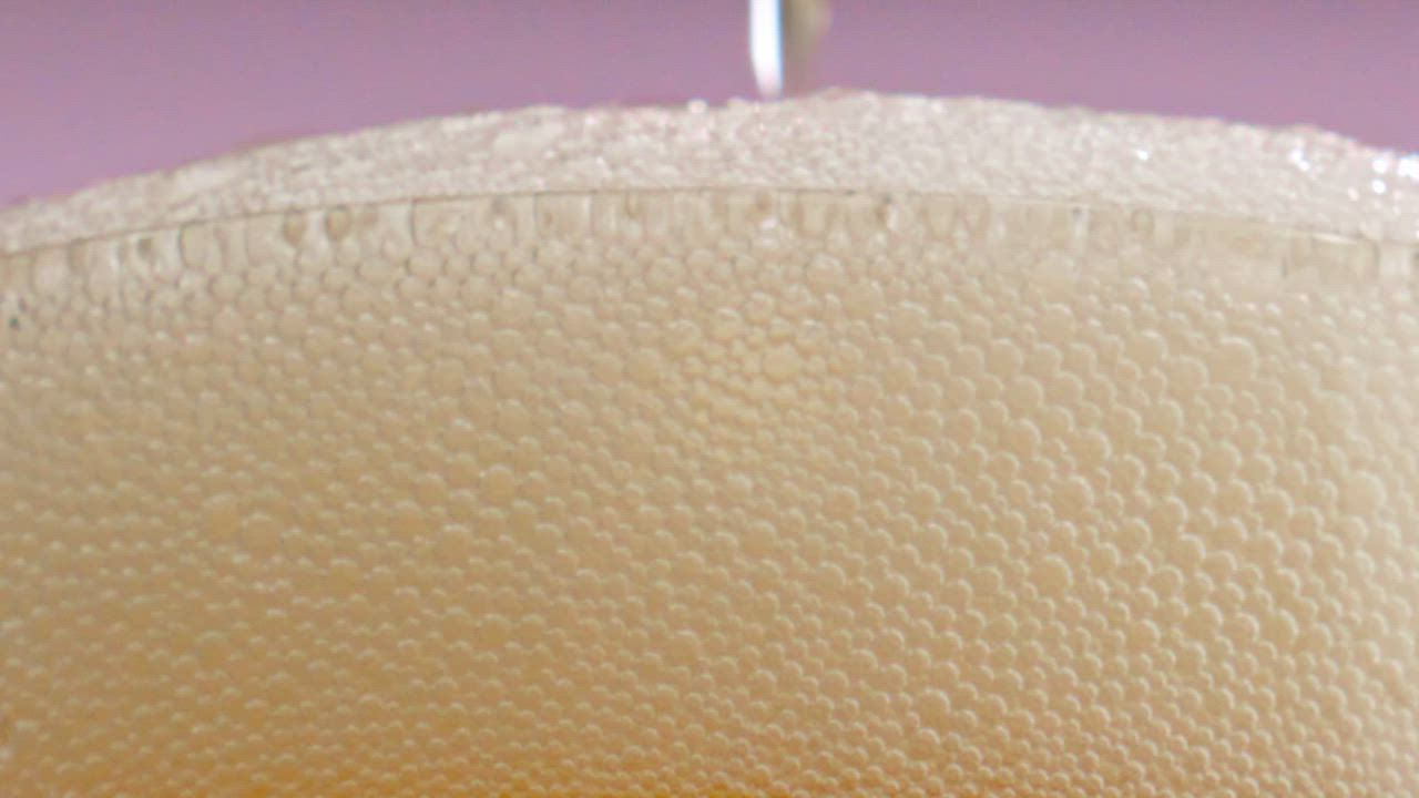 Effervescent beer foam and bubbles close up - Free Stock Video