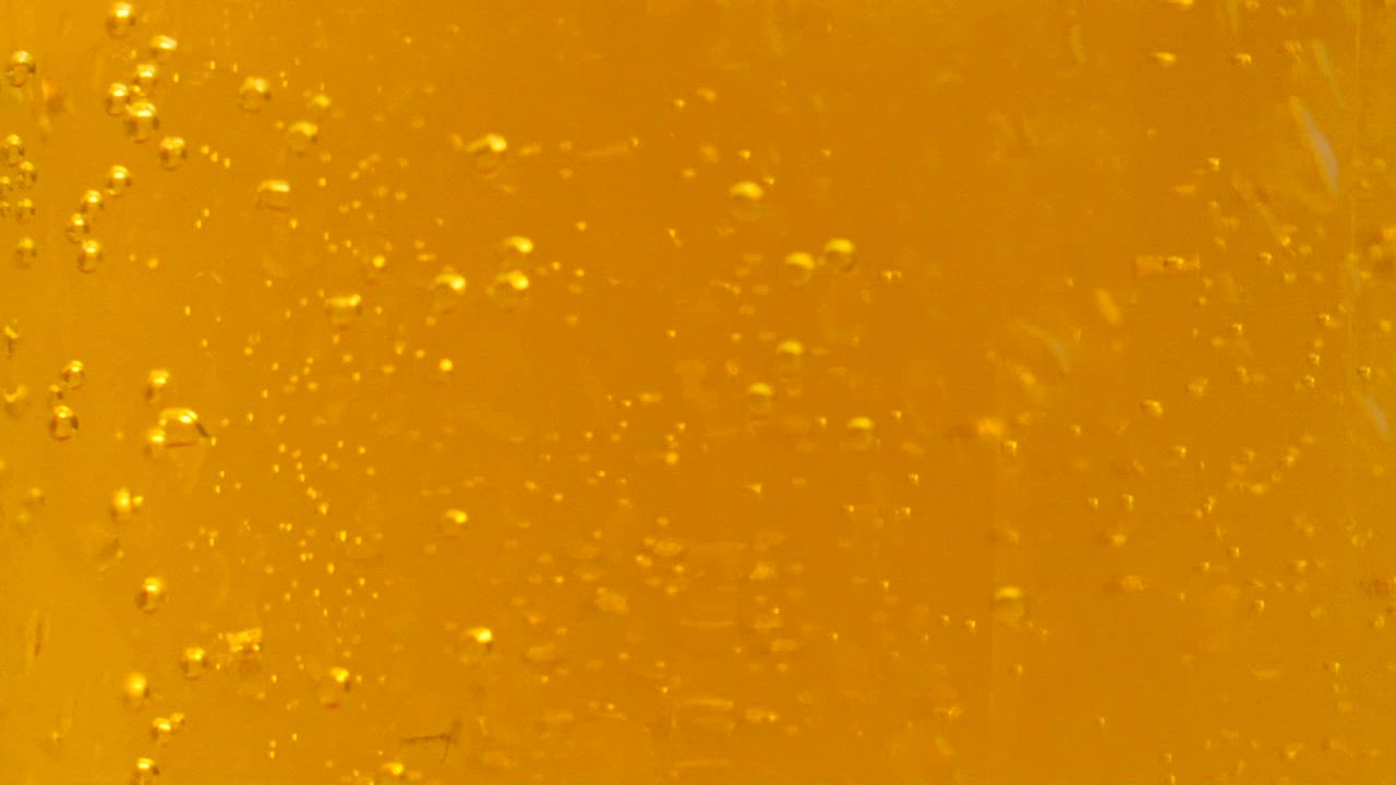 Texture of beer effervescent bubbles going upwards - Free Stock Video