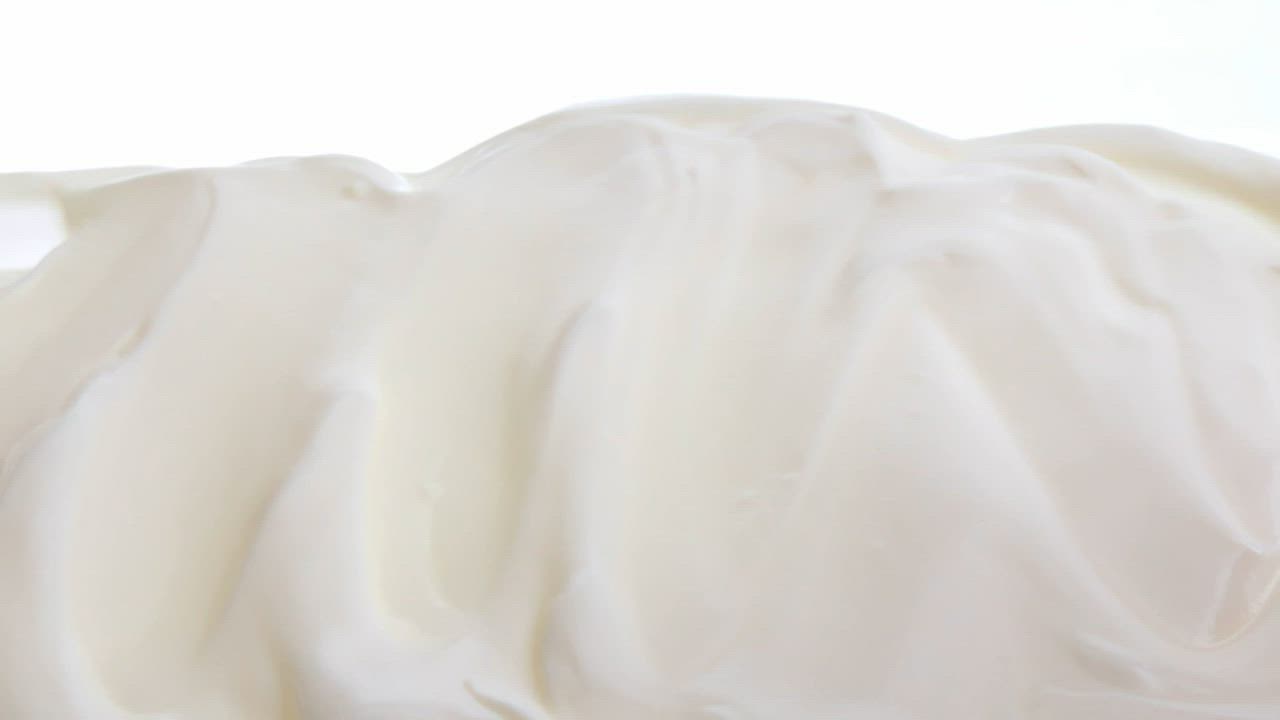 Thin slices of strawberry falling over whipped cream - Free Stock Video