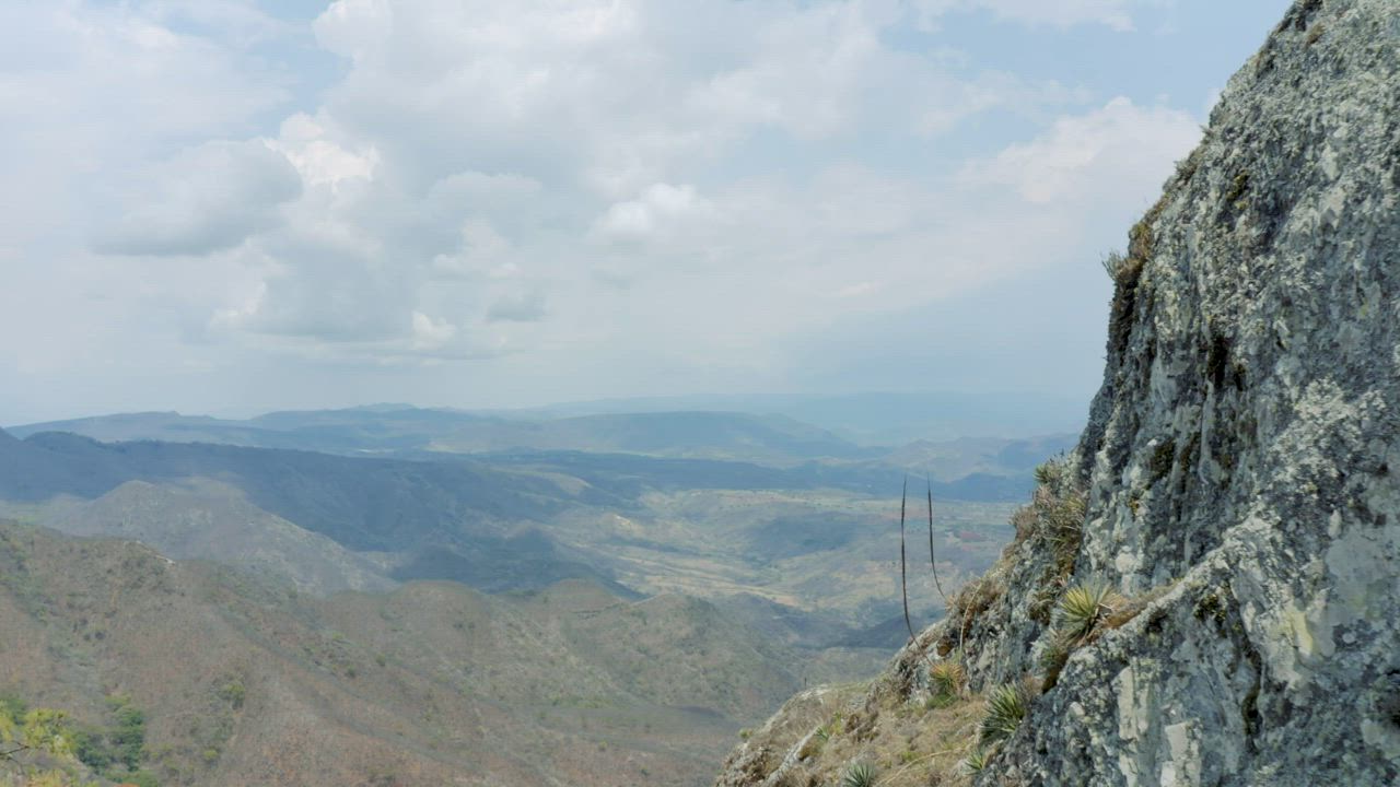 Reverse shot of an aerial view of a valley and mountains in the ...