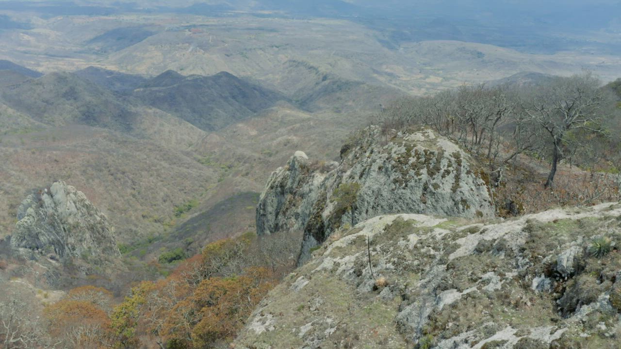 Aerial view of giant rocks at the top of a mountain and a valley in the ...