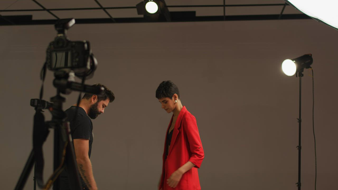 A photographer sets up a model for a photoshoot - Free Stock Video