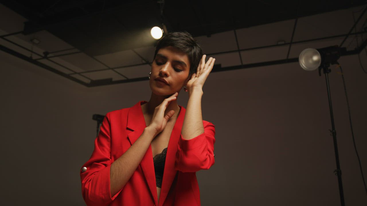 Model in a fashion shoot poses under lights - Free Stock Video