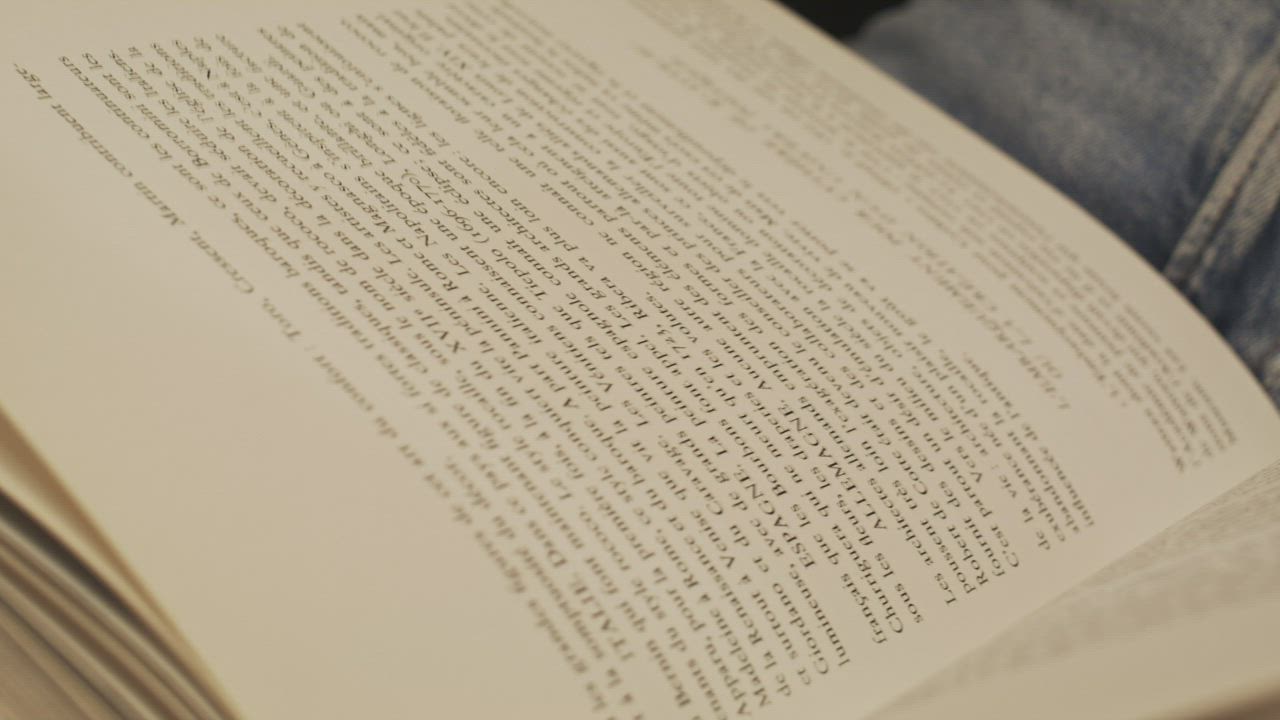 A woman gently turning the pages of a book - Free Stock Video