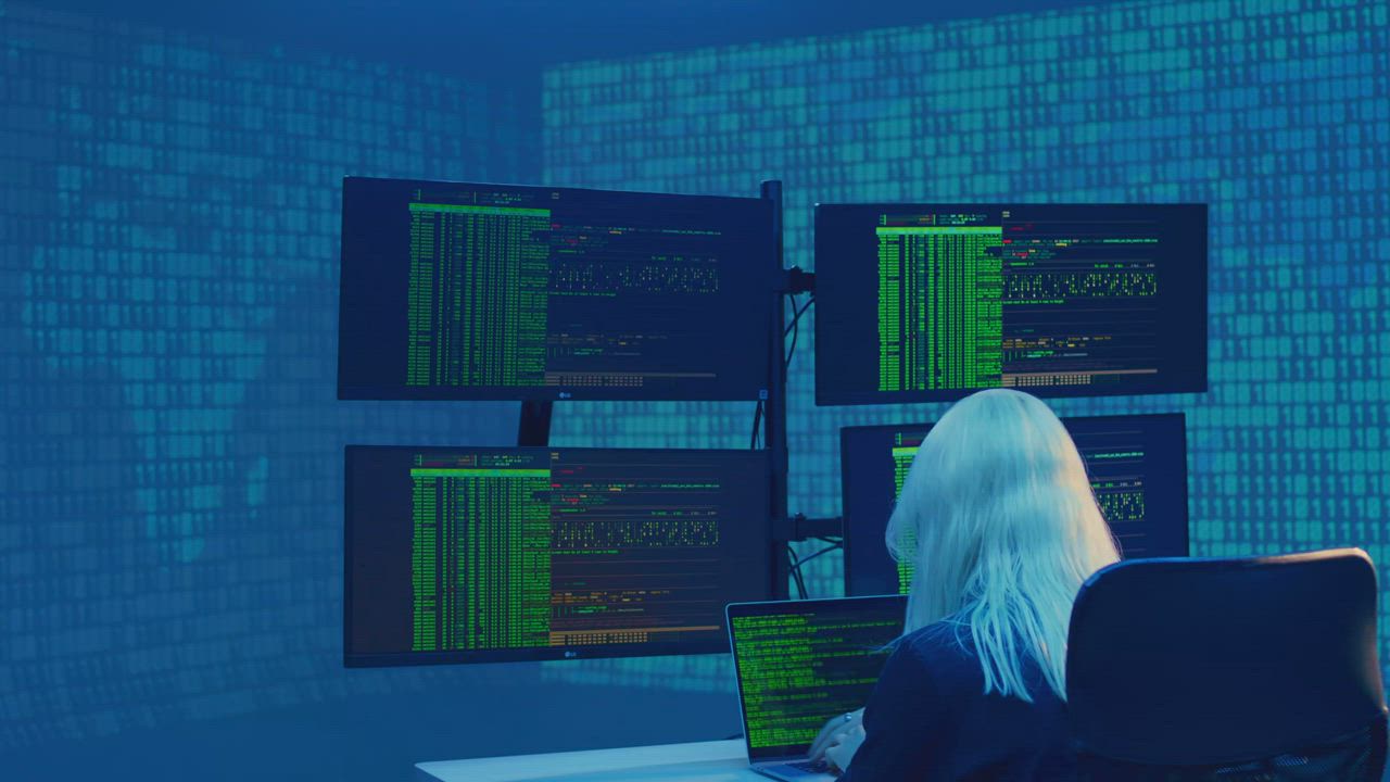A hacker is in front of various screens with technological patterns ...