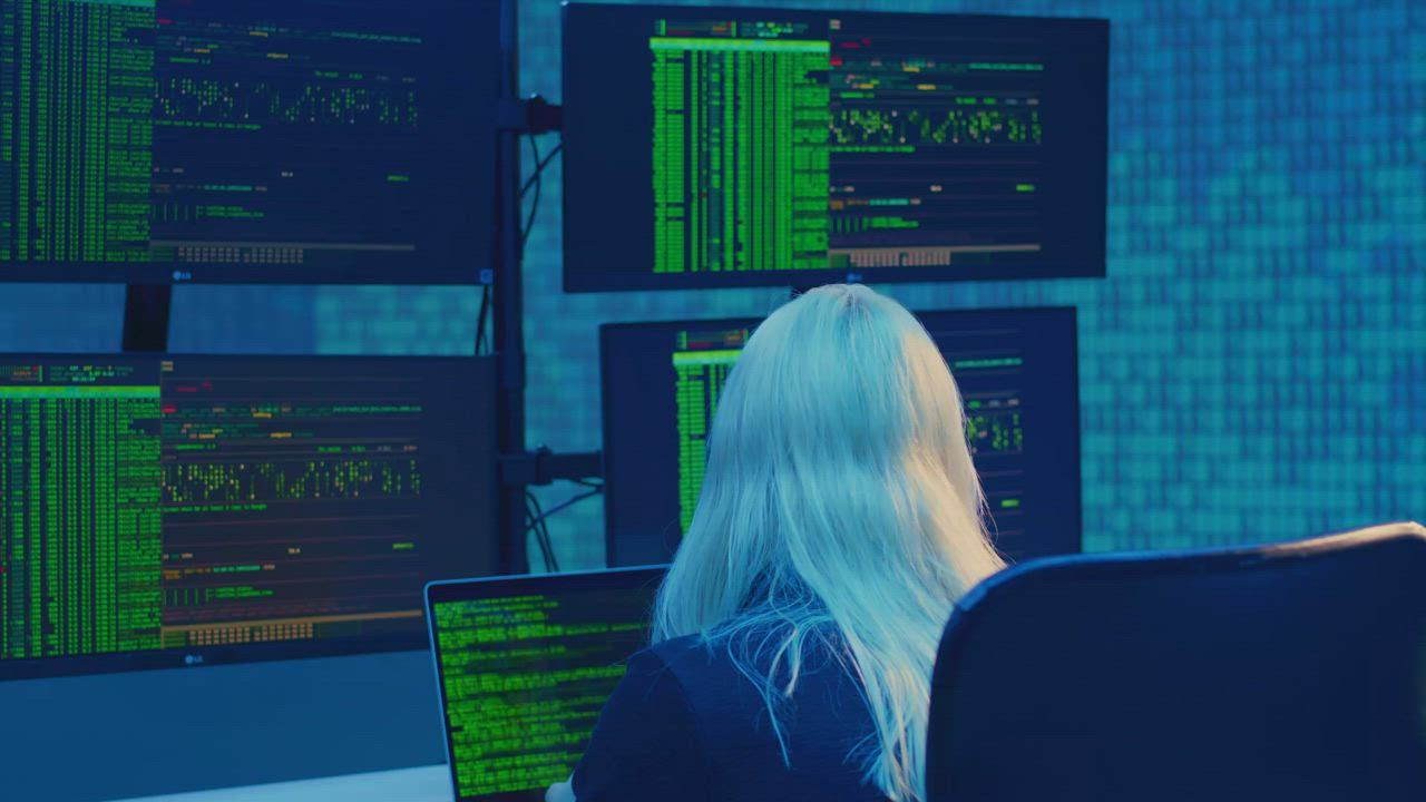 Script code running on four screens in front of a hacker - Free Stock Video