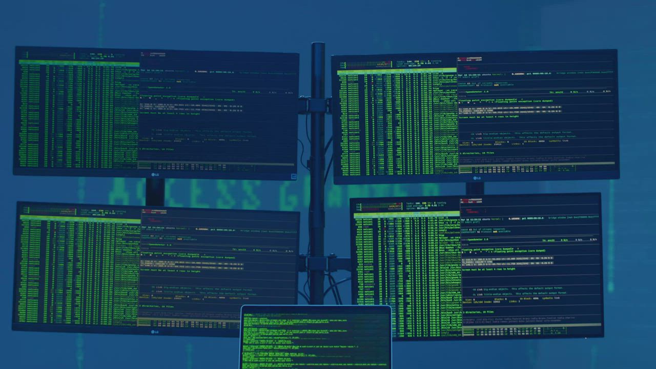 A laptop and four screens running green text scripts - Free Stock Video